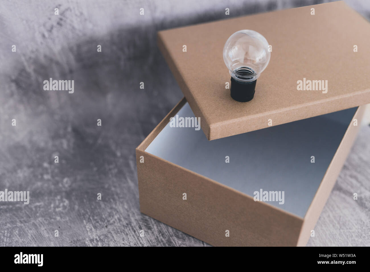 think outside the box concept: open empty box with one lightbulb ...