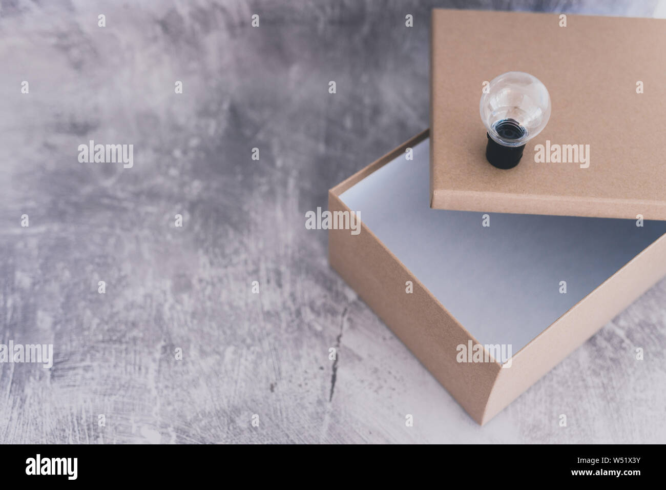 think outside the box concept: open empty box with one lightbulb ...