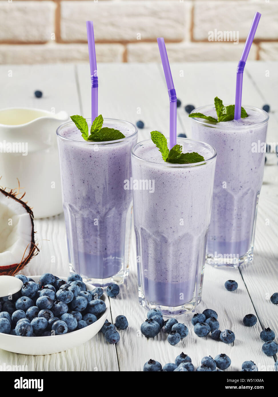 close-up of blueberry frothy milkshake of coconut milk in three glasses ...