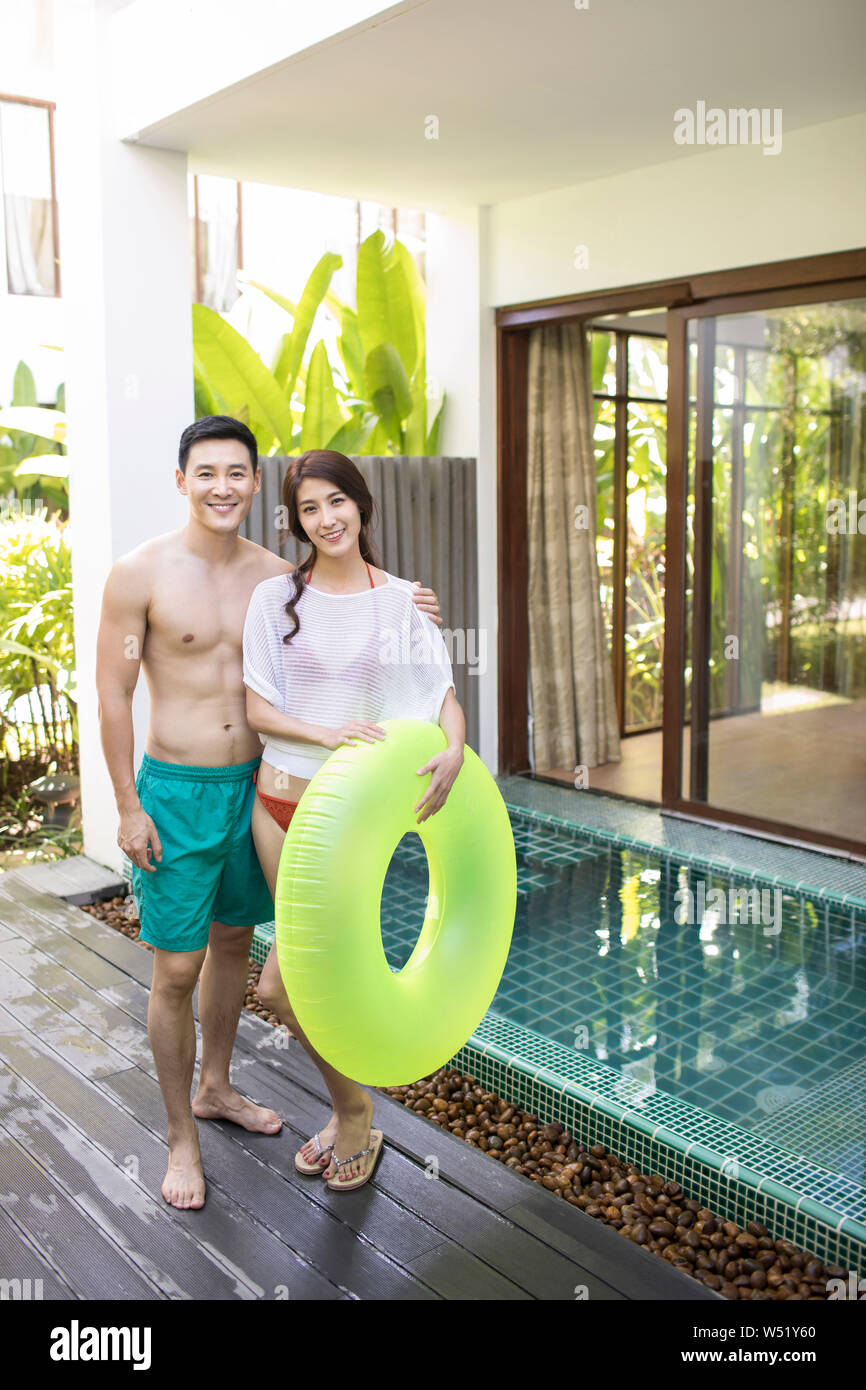 Happy young couple at poolside Stock Photo - Alamy