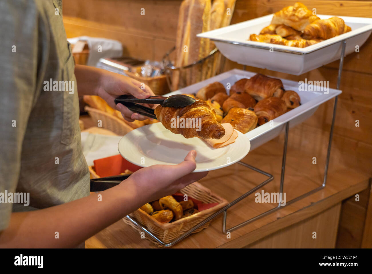 Human hand picking croissant while having breakfast at hotel Stock ...