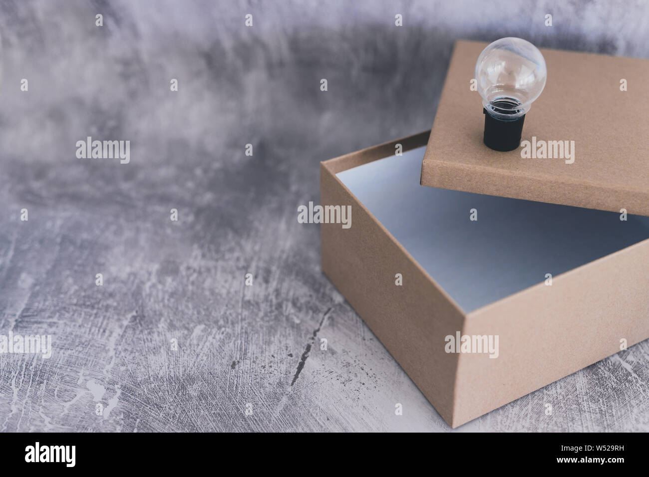 think outside the box concept: open empty box with one lightbulb ...