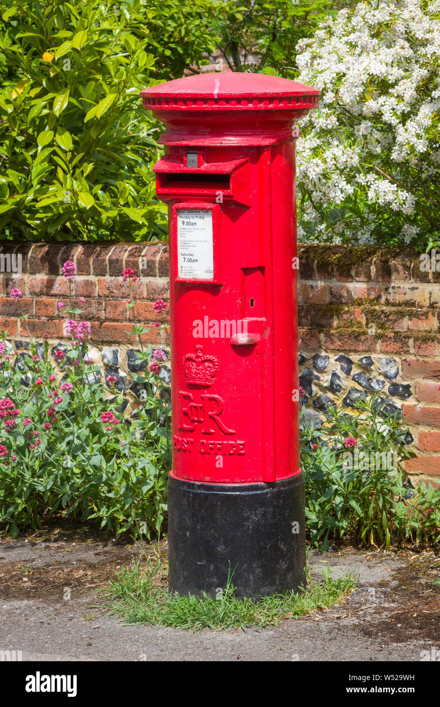A traditional red Post Box by a brick and flit wall in South Stoke ...