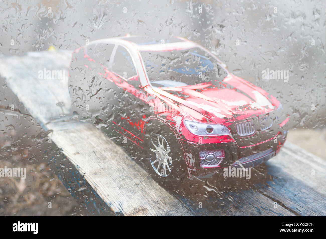 Red toy car outside in the rain. Childhood problems concept Stock Photo ...