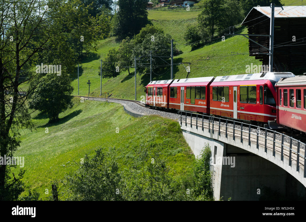 St. Peter, GR / Switzerland - 24. July, 2019: red narrow gauge train ...