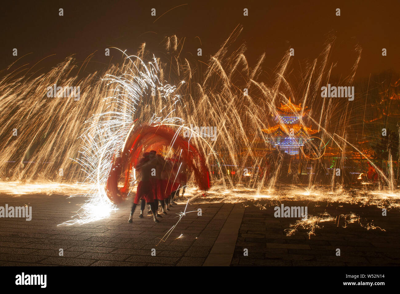 Chinese entertainers perform a fire dragon dance in a shower of molten ...