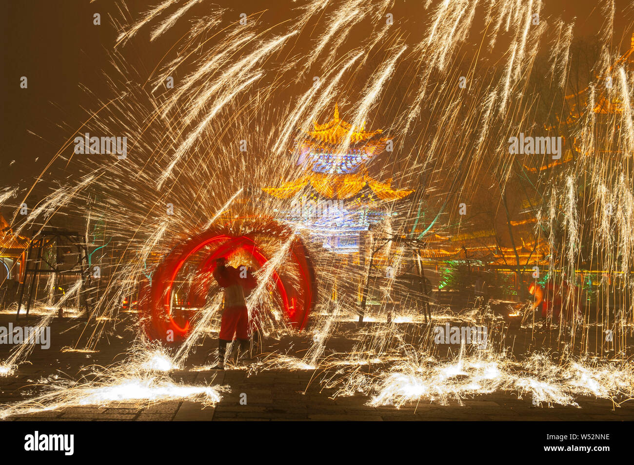Chinese entertainers perform a fire dragon dance in a shower of molten ...