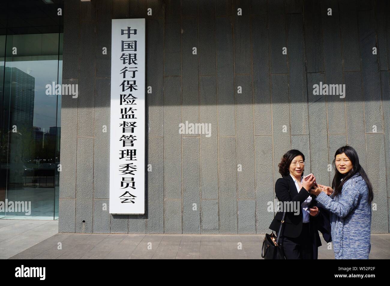 --FILE--Visitors take photos in front of the headquarters of China ...