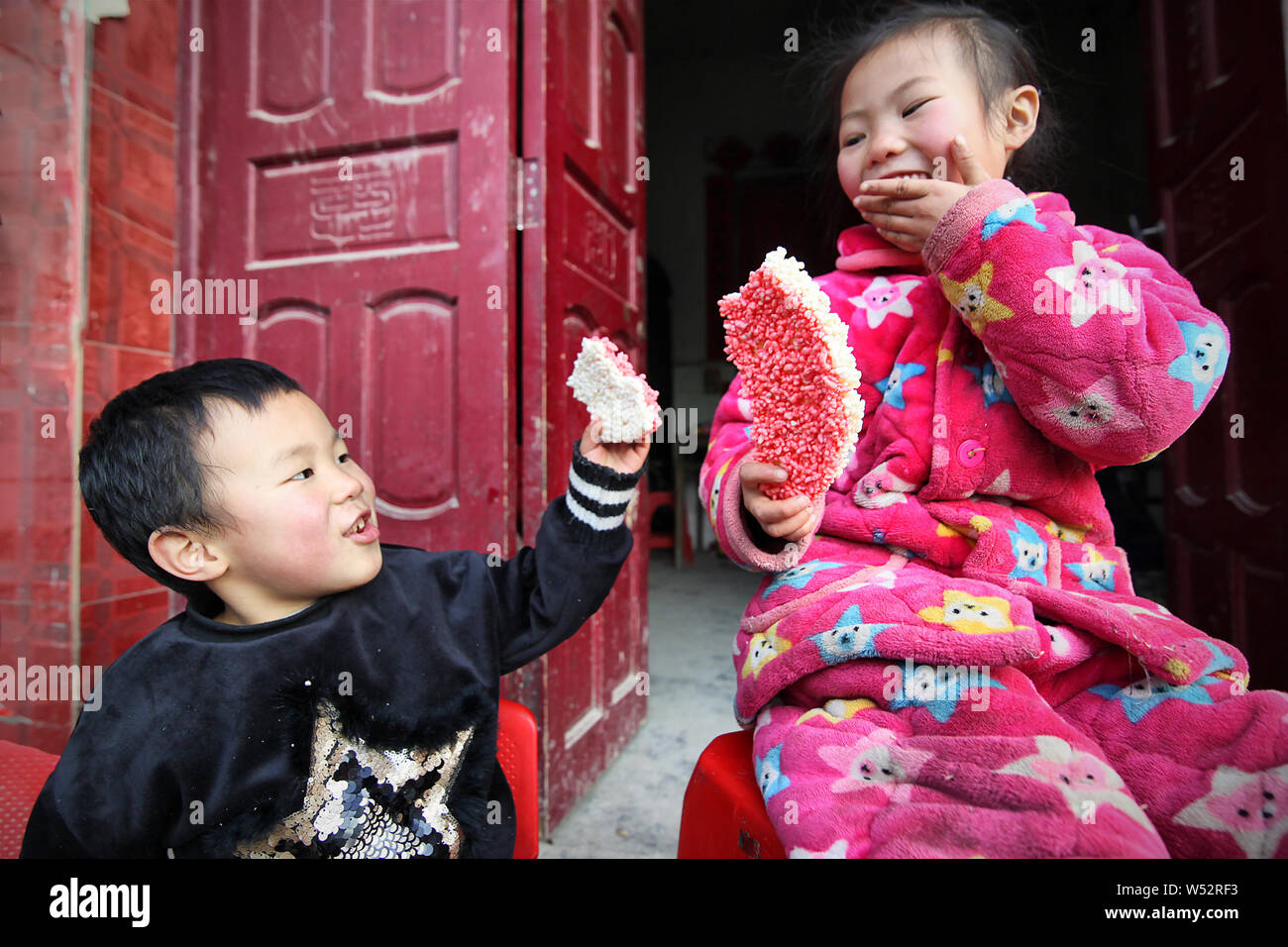 Children eat puffed rice cakes, one of the festive foods, to mark the ...