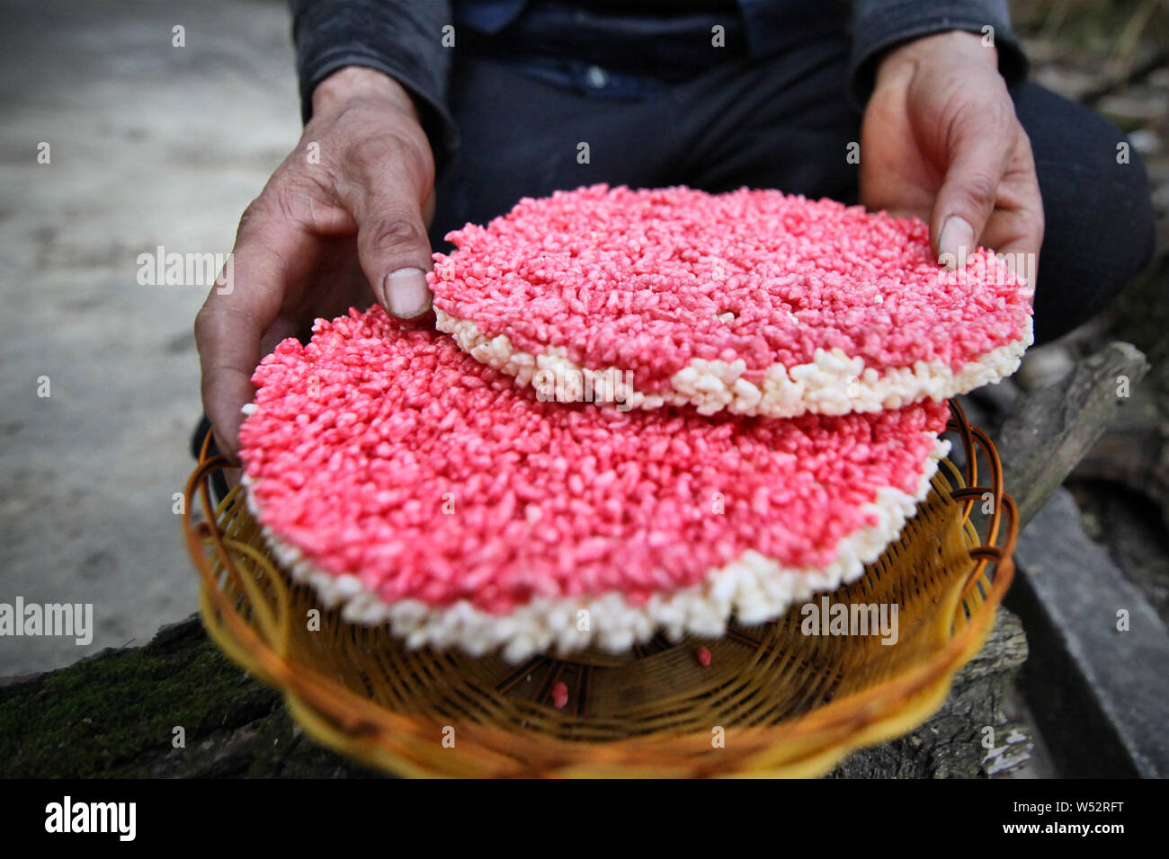 A Chinese villager airs red puffed rice cakes, one of the festive foods ...