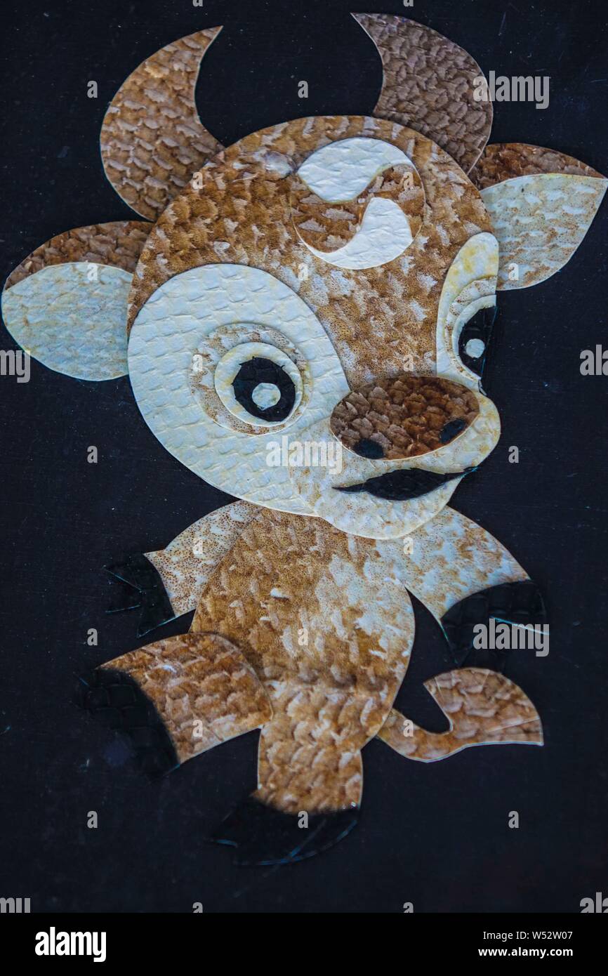 A painting made of fish skins by the Hezhen People is on display at a ...