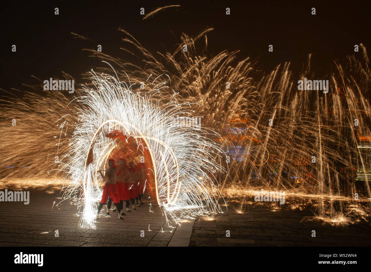 Chinese entertainers perform a fire dragon dance in a shower of molten ...