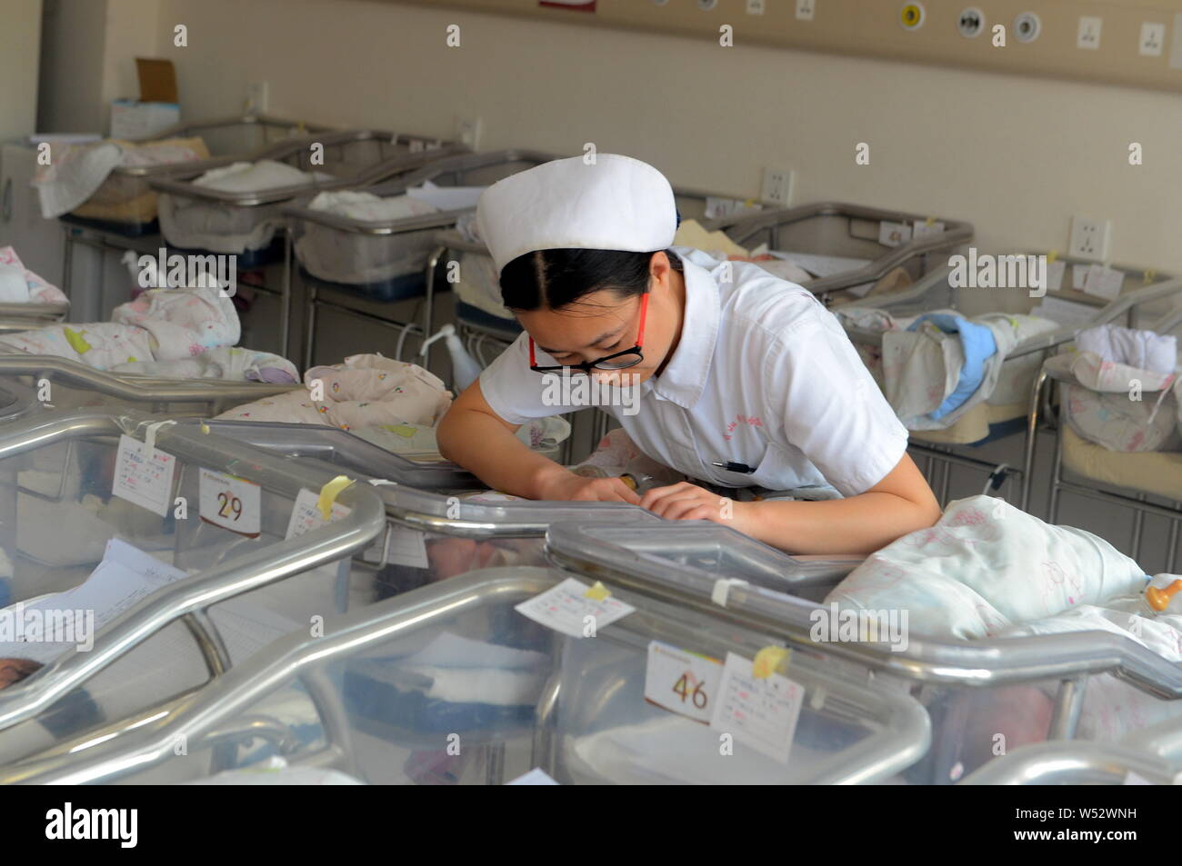 --FILE--A Chinese nurse takes care of newborn babies at a maternity ...