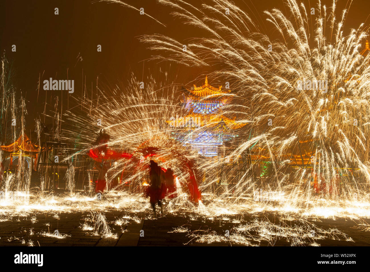 Chinese entertainers perform a fire dragon dance in a shower of molten ...