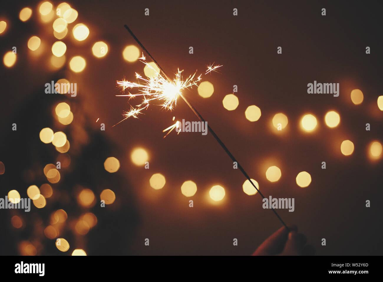 Happy New Year. Glowing sparkler in hand on background of golden ...