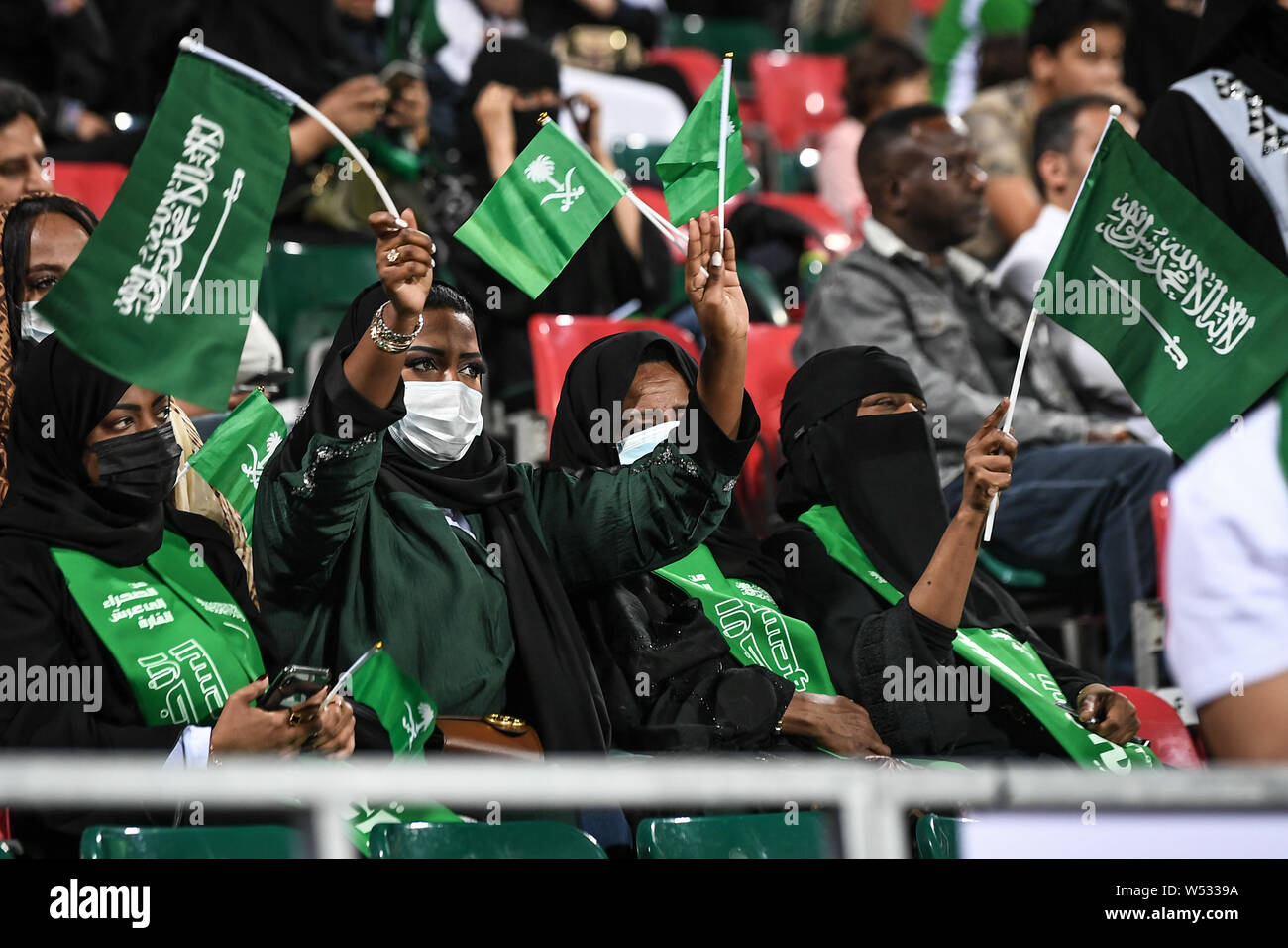 Saudi Arabian football fans hold up their national flags to show ...