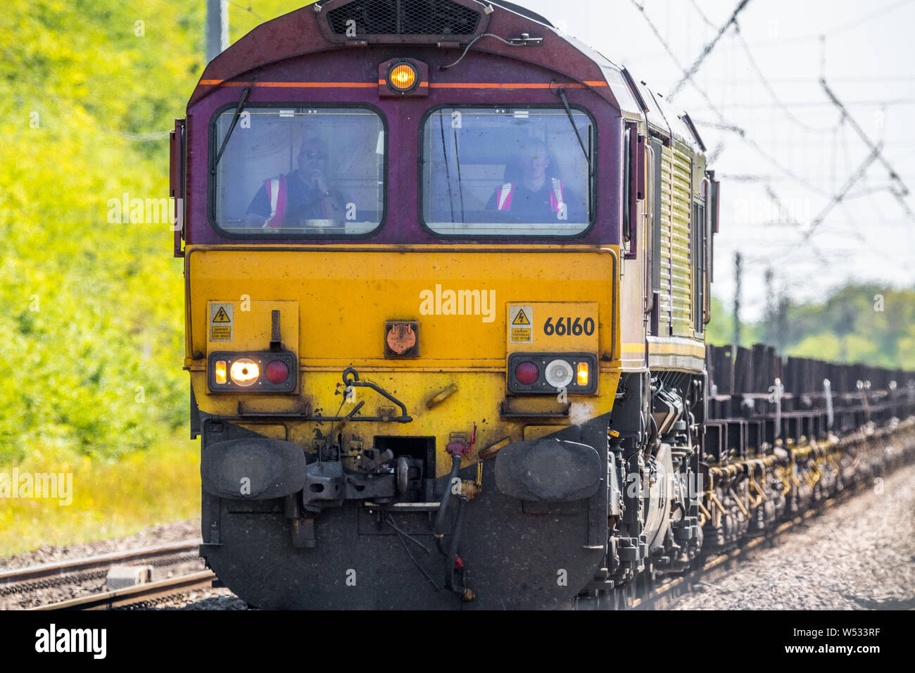 Freight train pulling empty trailers for carrying steel rail tracks ...