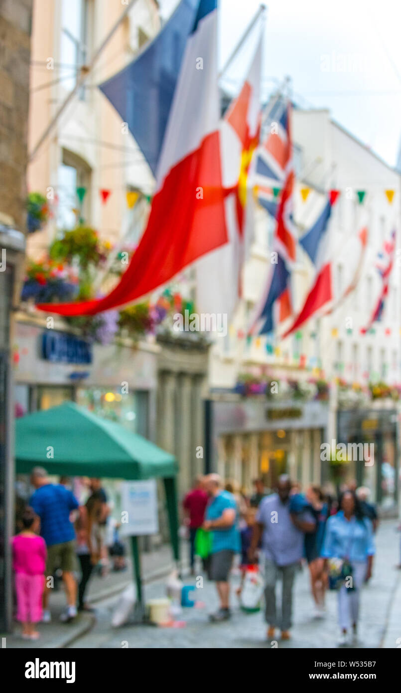 Flags,bunting and flowers on display on a busy shopping street in ...