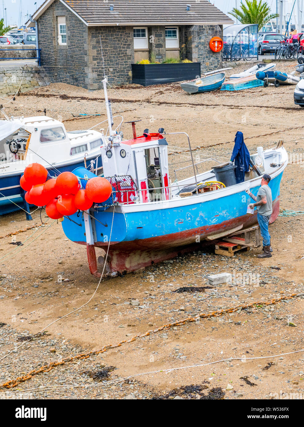 Local fishing boats at low tide in Victoria Harbour on the Channel ...