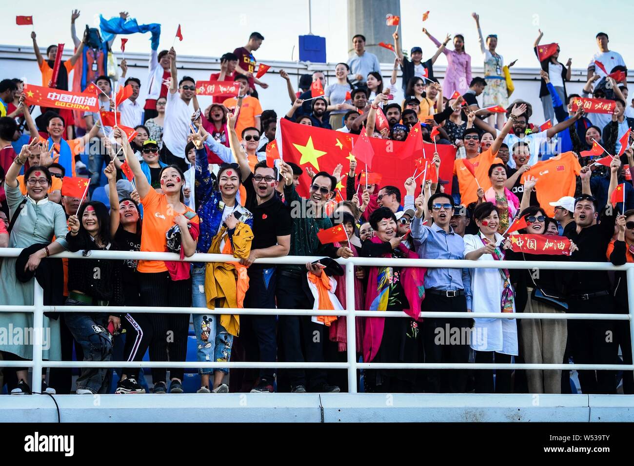 Chinese football fans hold up Chinese national flags to show support ...