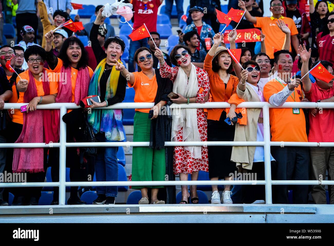 Chinese football fans hold up Chinese national flags to show support ...