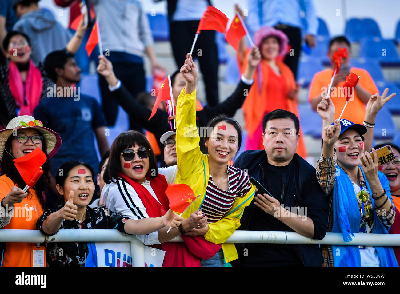 Chinese football fans hold up Chinese national flags to show support ...