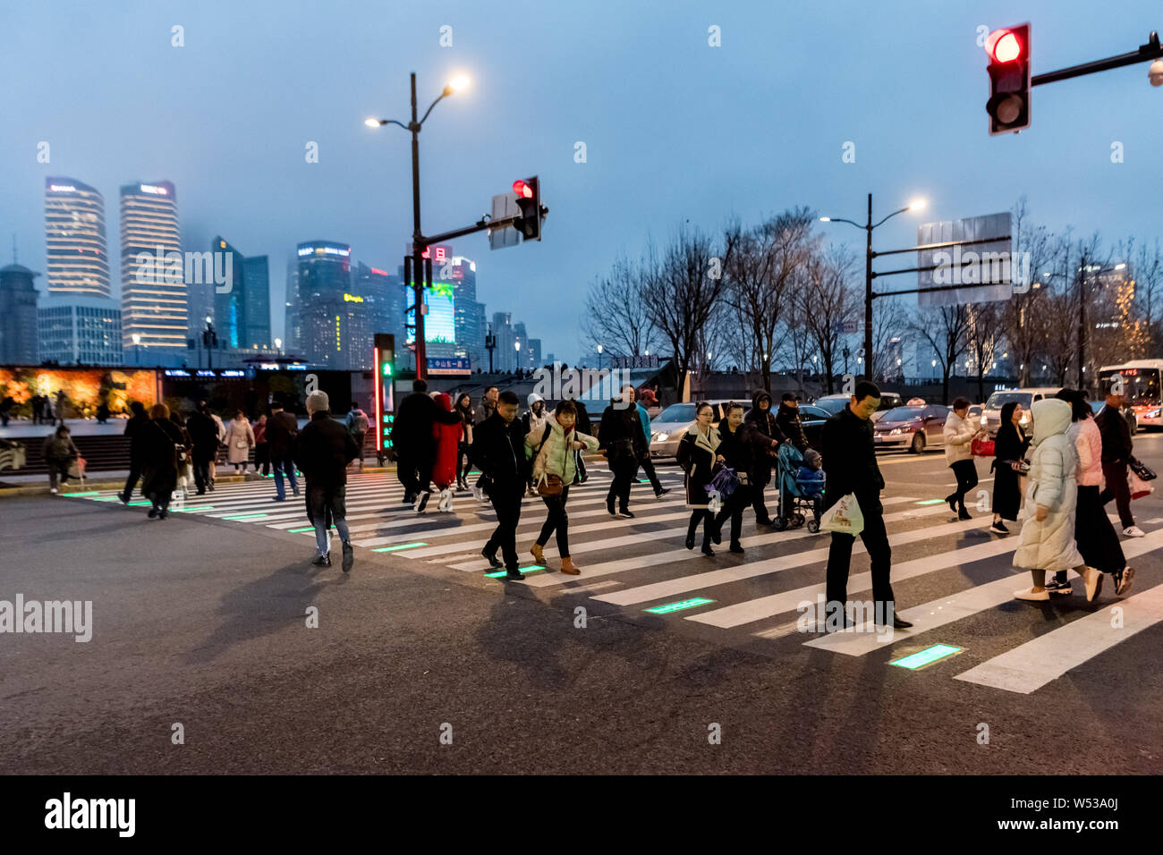 Pedestrians walk across a zebra crossing illuminated by LED lights in ...