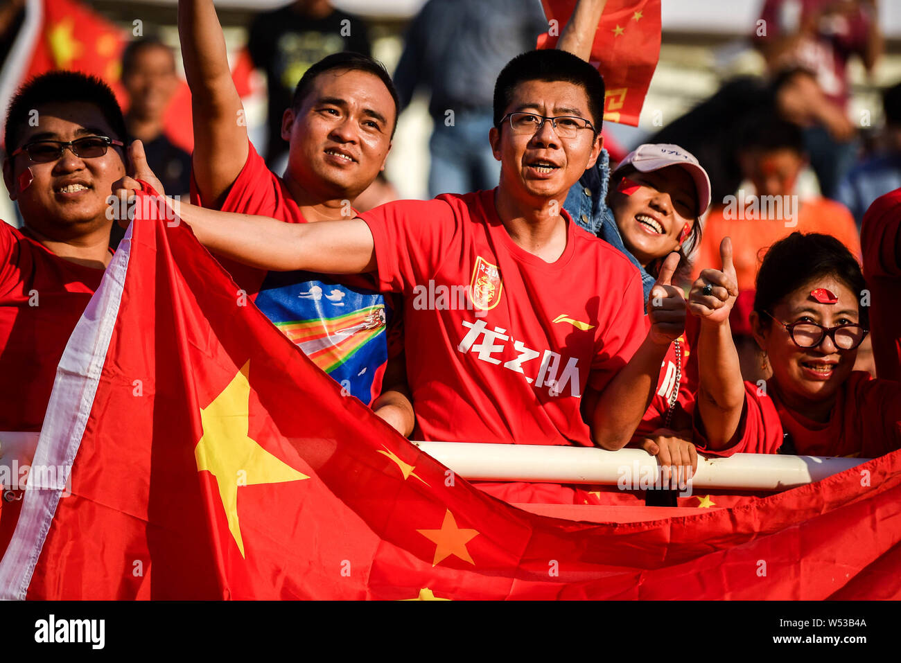 Chinese football fans hold up Chinese national flags to show support ...