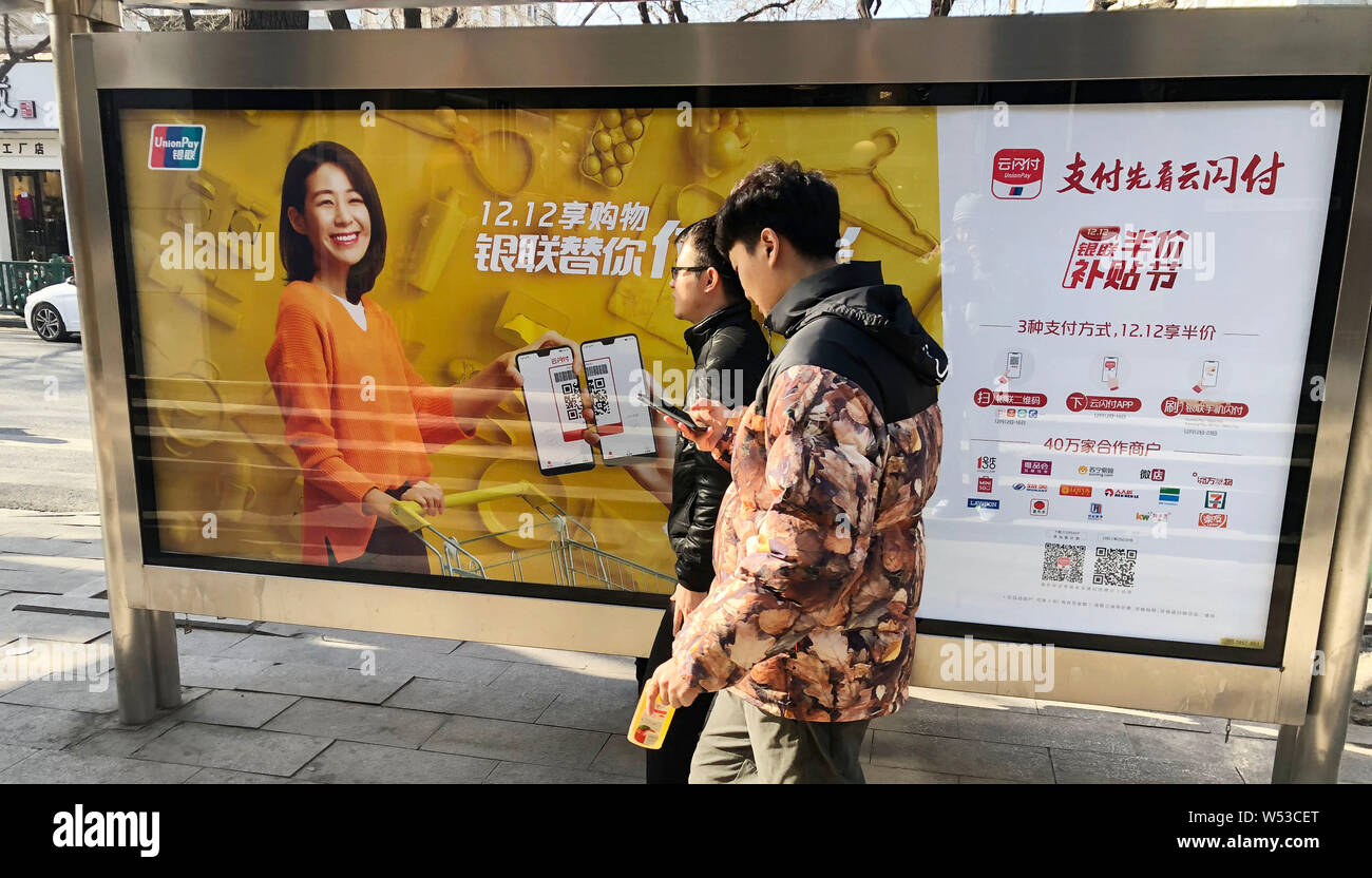 --FILE--Pedestrians walk past an advertisement for China UnionPay in ...
