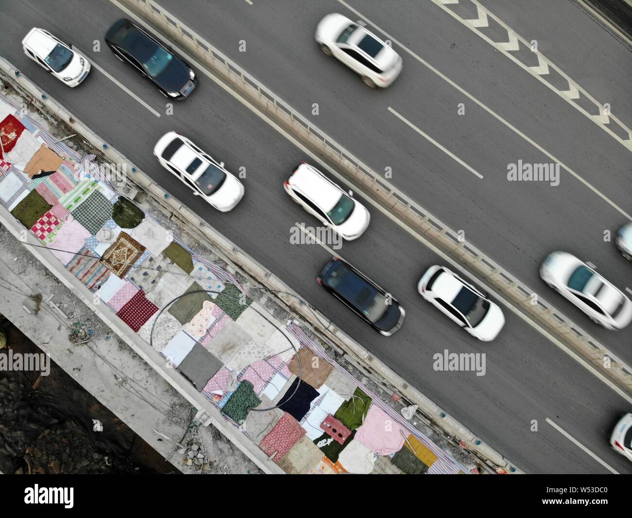 Cars pass by a newly-constructed ramp covered with quilts on an ...