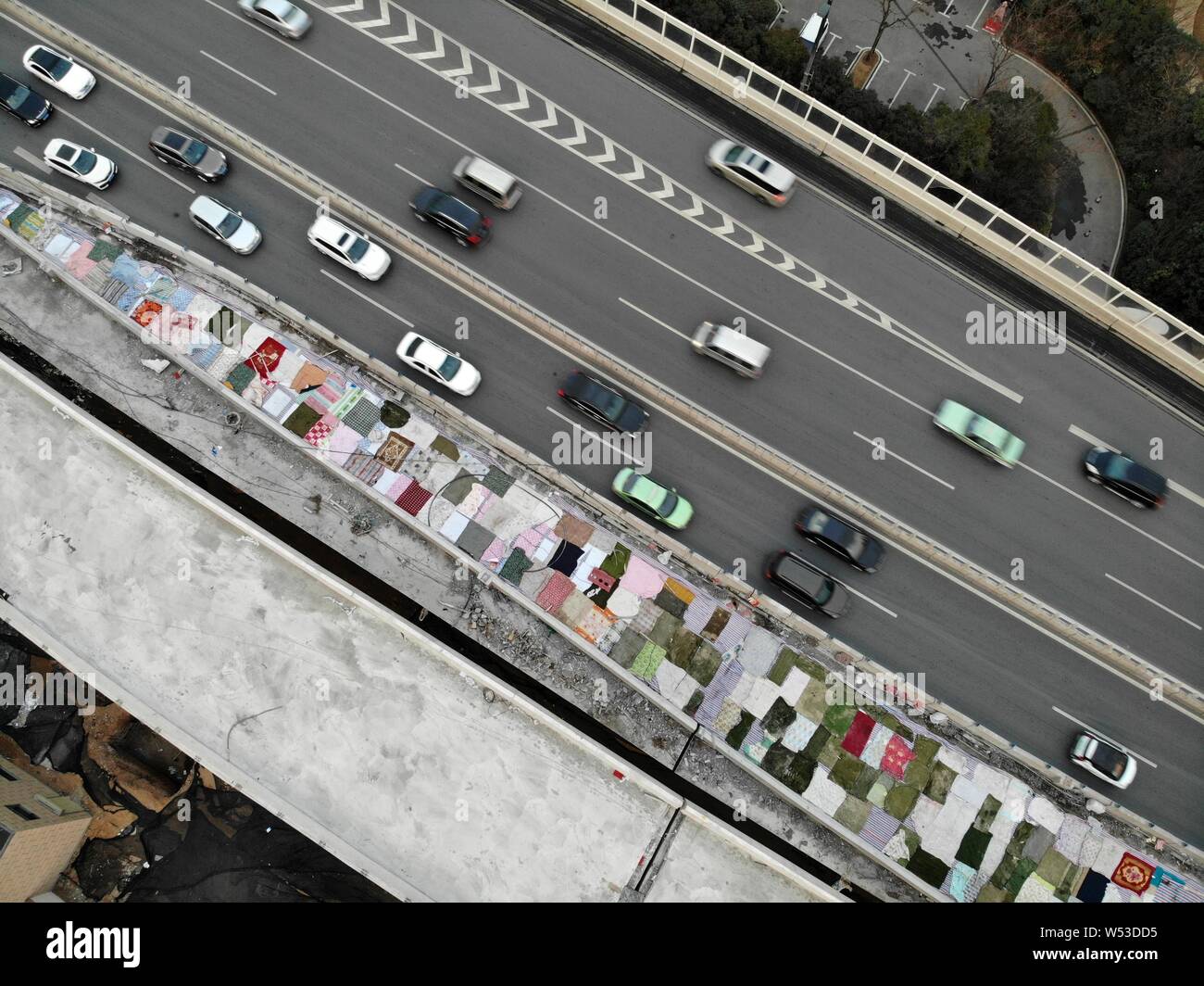 Cars pass by a newly-constructed ramp covered with quilts on an ...