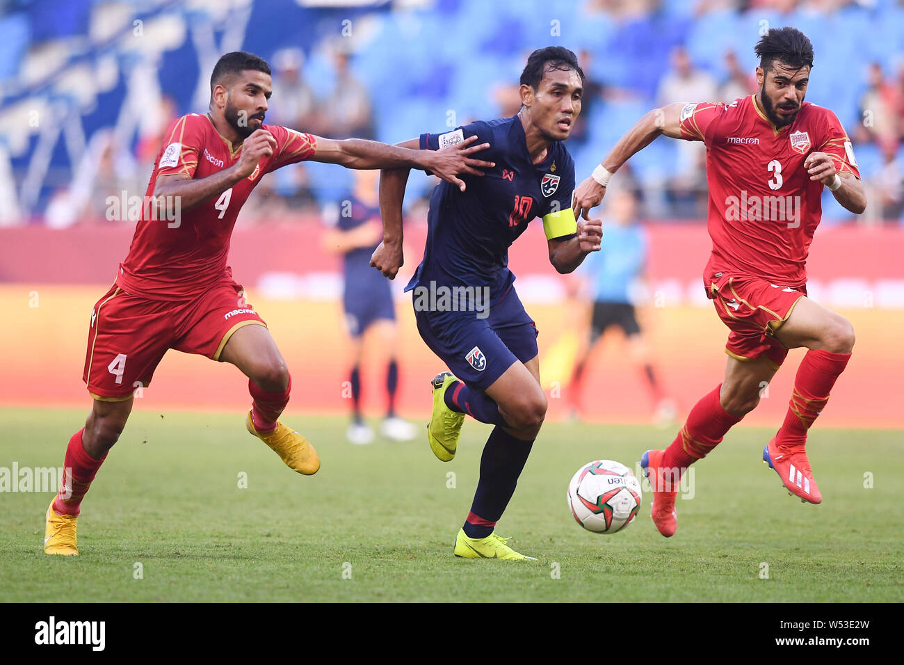 Teerasil Dangda, center, of Thailand dribbles against Sayed Dhiya Saeed ...