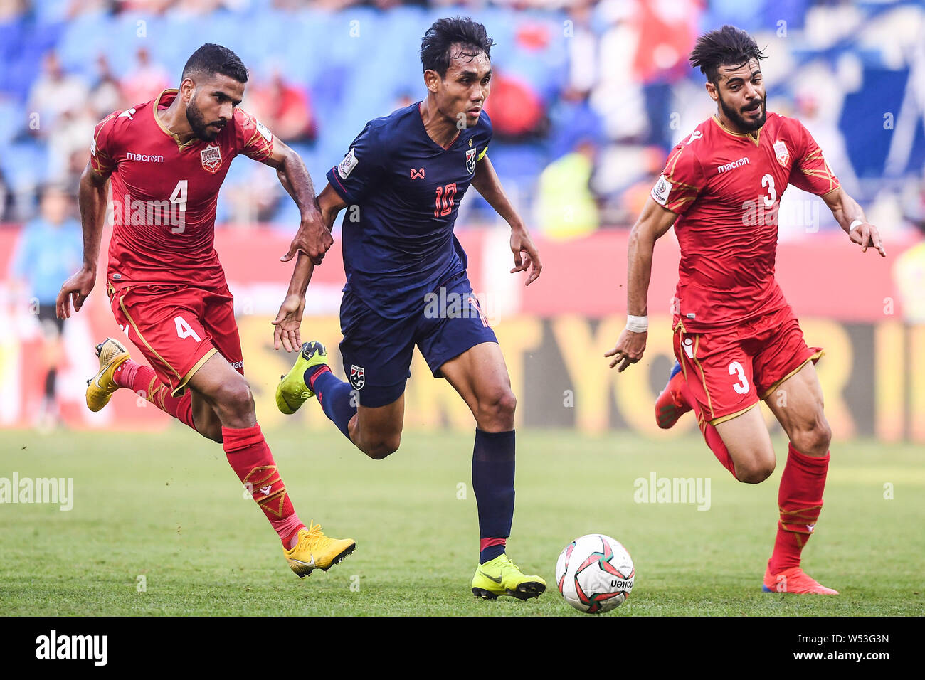 Teerasil Dangda, center, of Thailand dribbles against Sayed Dhiya Saeed ...