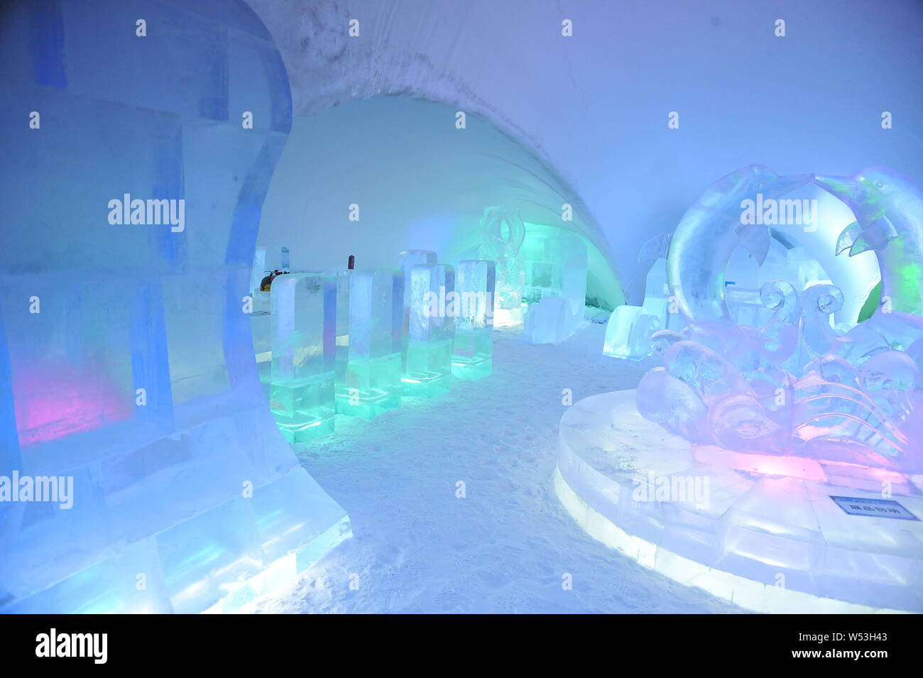 An ice table and ice chairs are on display at an arch-shaped ice hotel ...