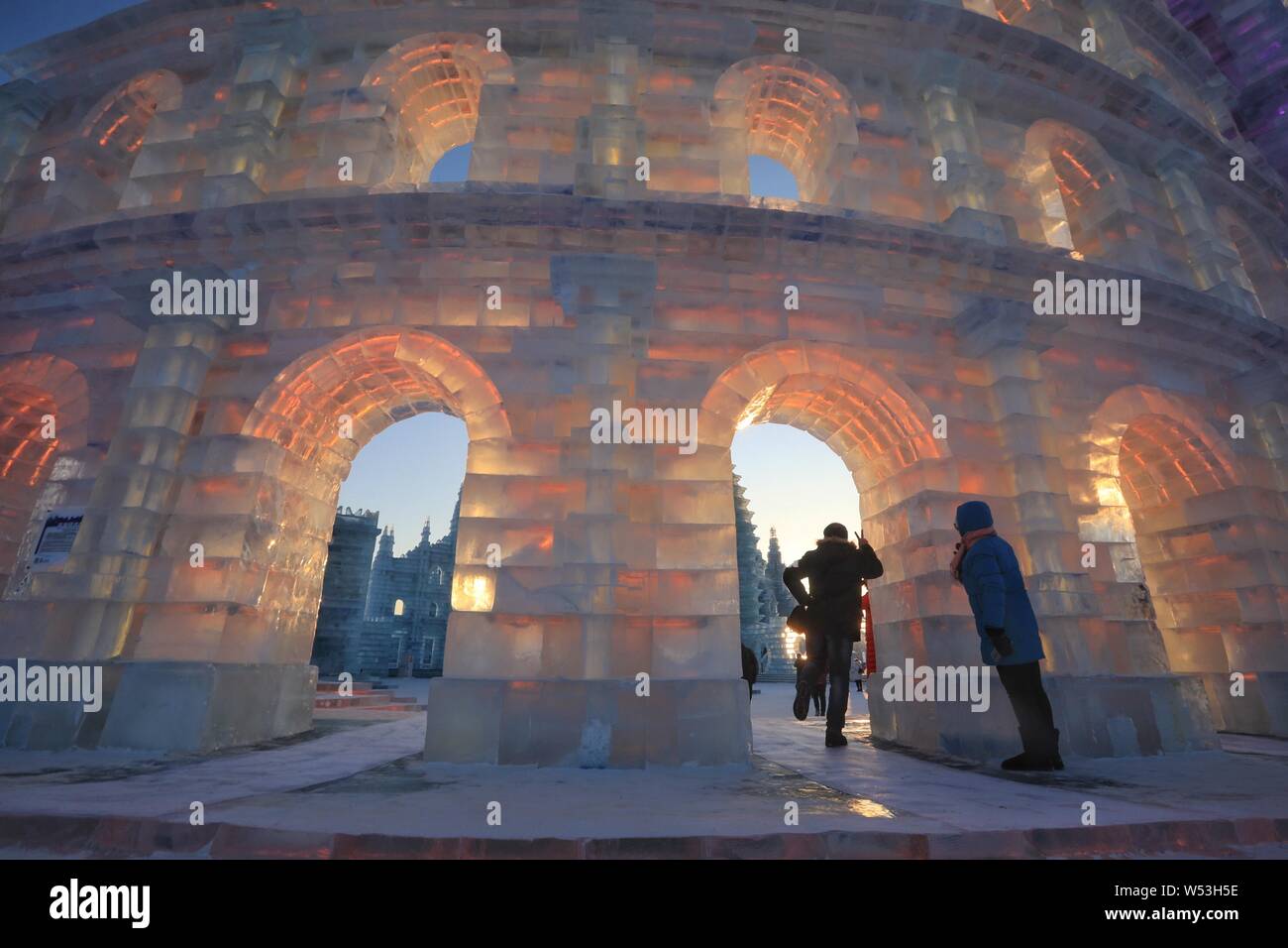 Visitors pose for pictures in a downsized ice replica of part of The ...