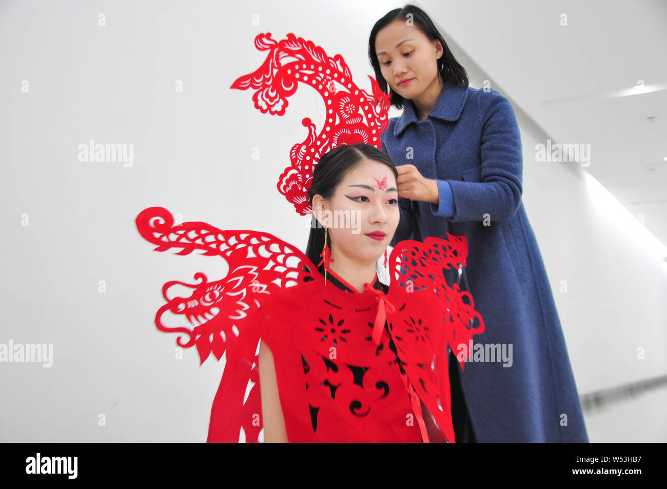Chinese craftswoman Liang Ying helps a model wear a cheongsam (qipao ...