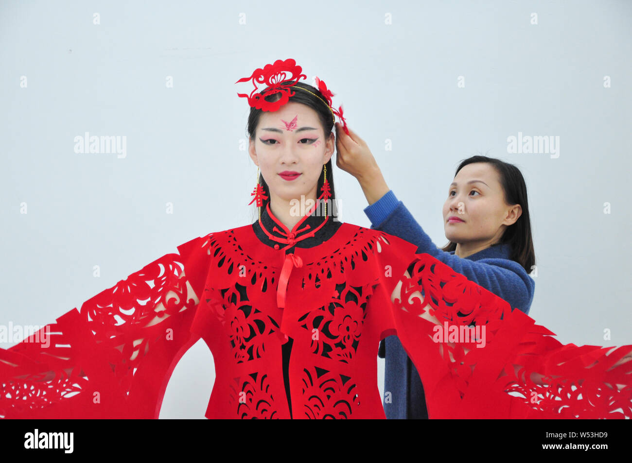 Chinese craftswoman Liang Ying helps a model wear a cheongsam (qipao ...