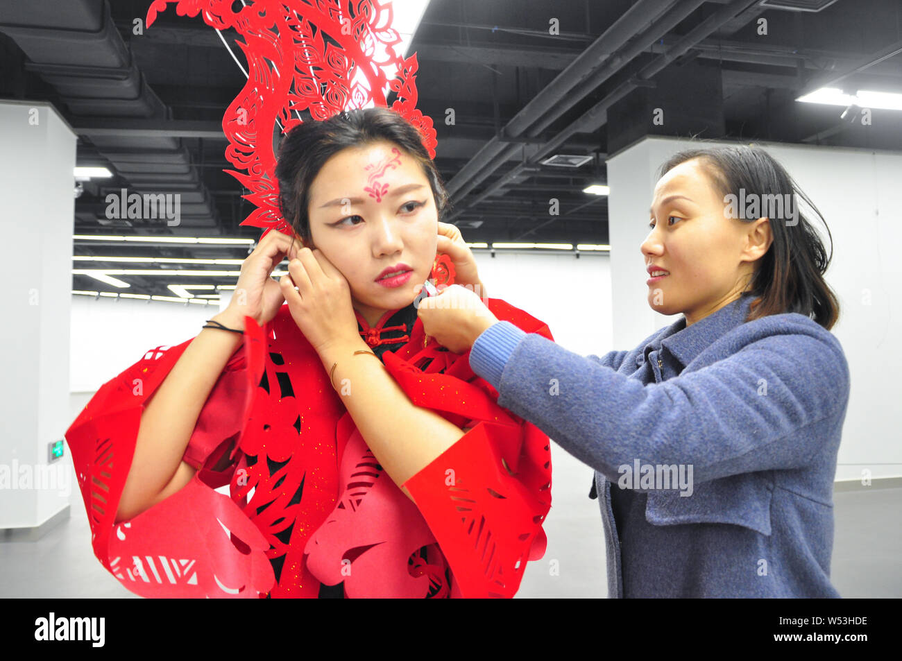Chinese craftswoman Liang Ying helps a model wear a cheongsam (qipao ...