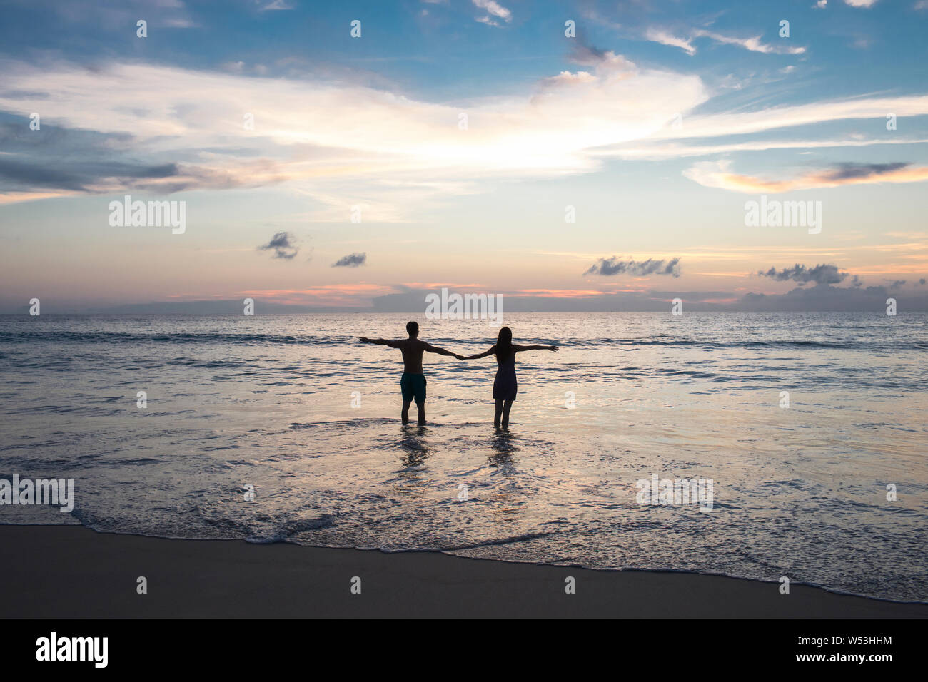 Young couple dating on beach at sunset Stock Photo - Alamy