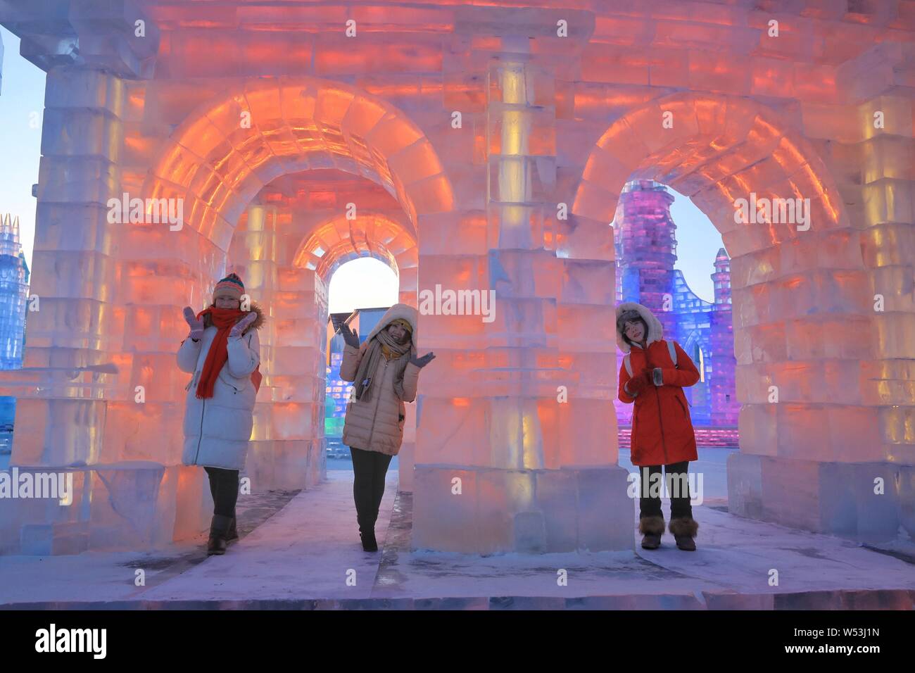 Visitors pose for pictures in a downsized ice replica of part of The ...