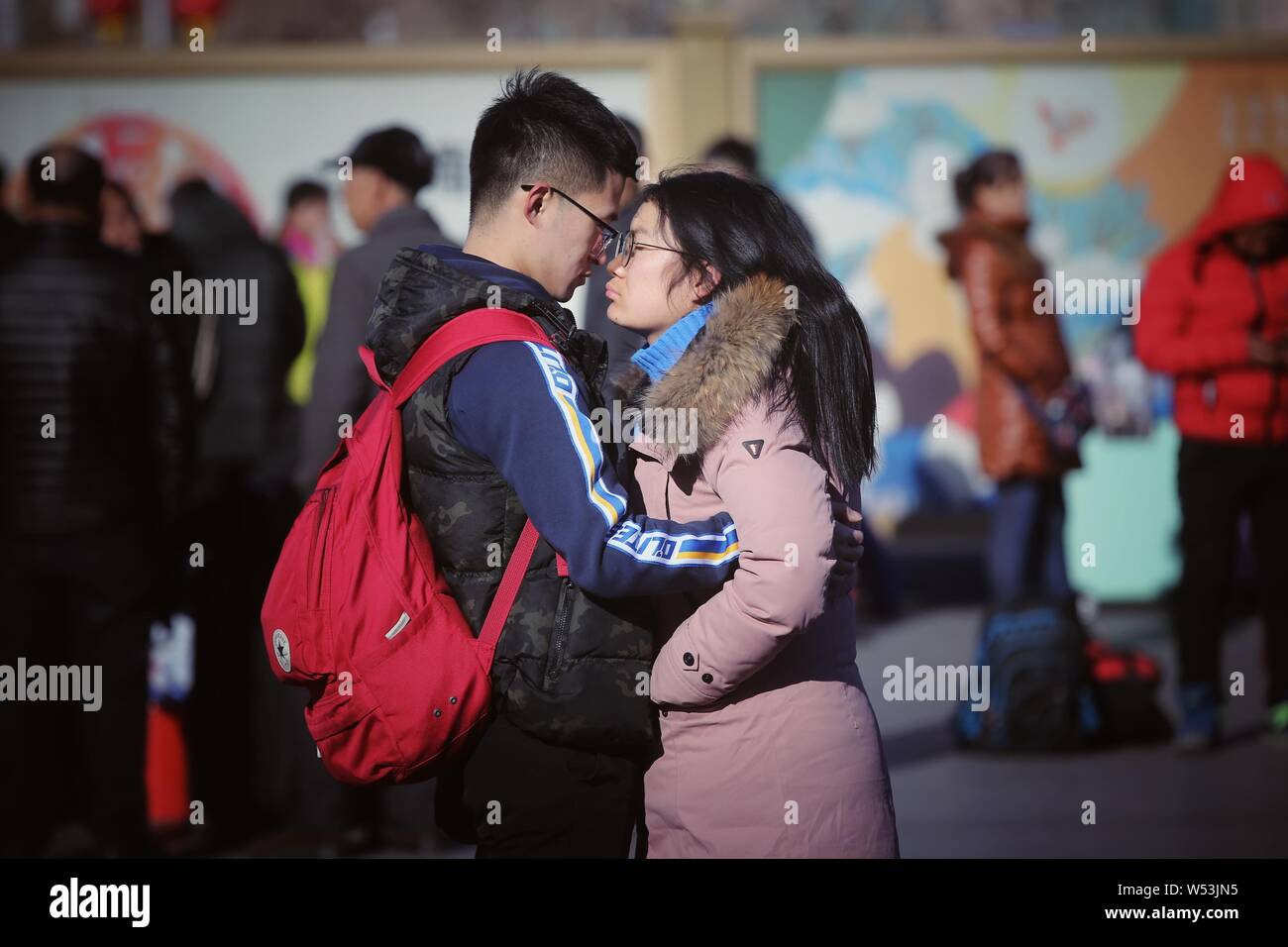 A couple of college students hugs and kisses to say goodbye as they are ...