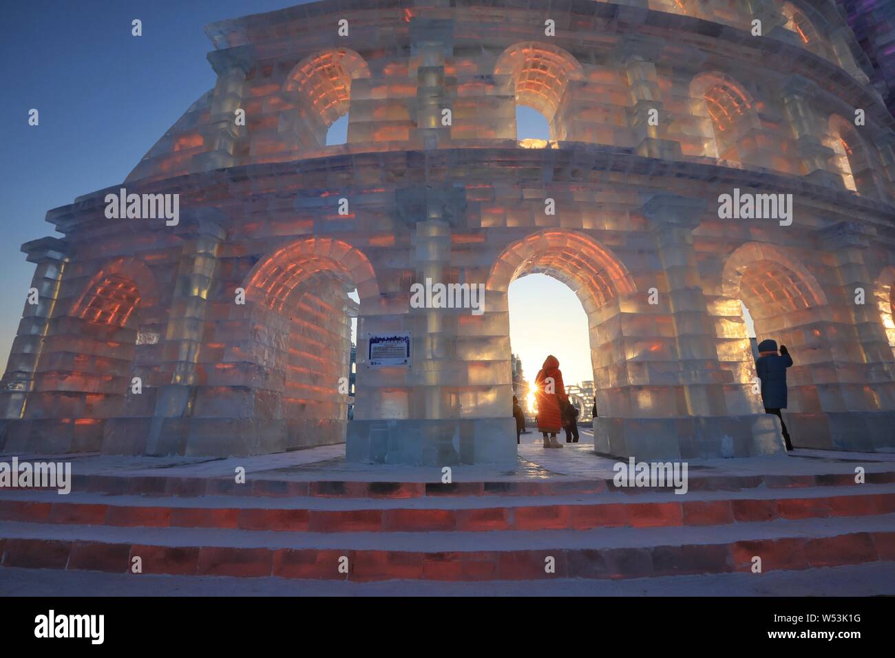 Visitors pose for pictures in a downsized ice replica of part of The ...