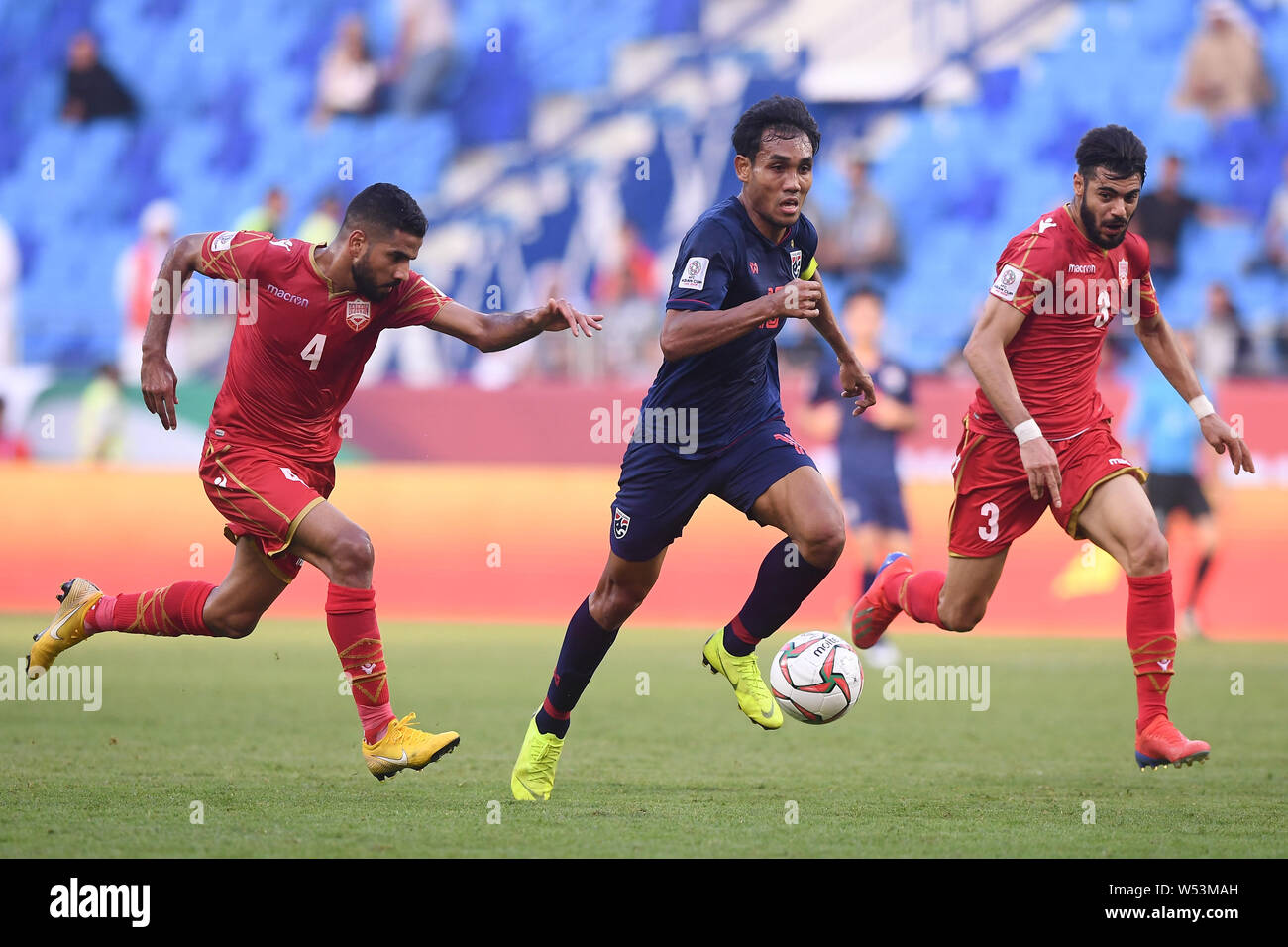 Teerasil Dangda, center, of Thailand dribbles against Sayed Dhiya Saeed ...