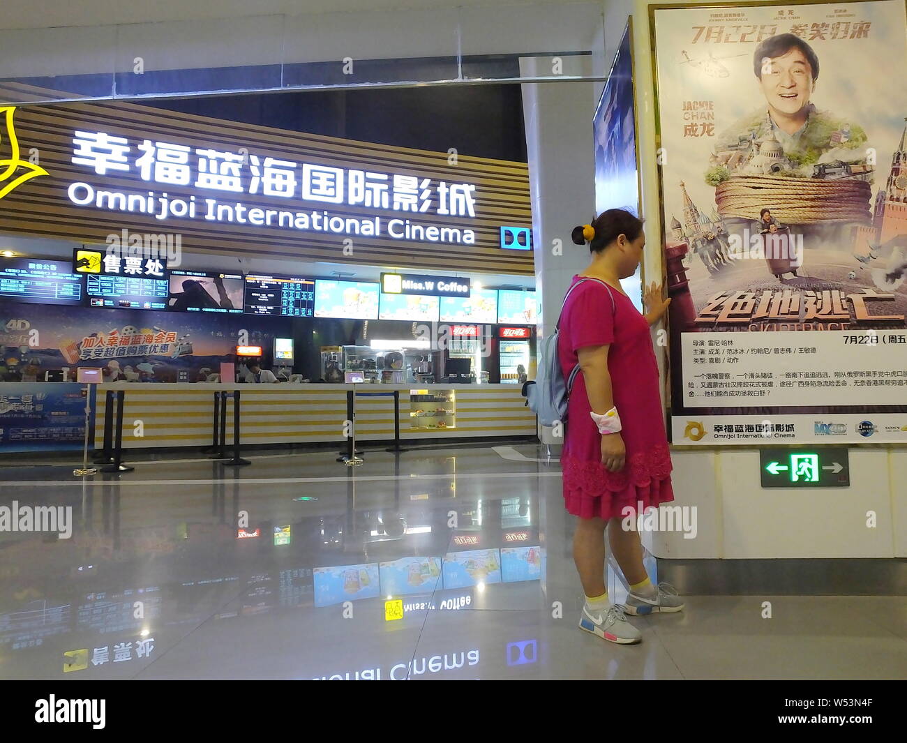 --FILE--A Chinese filmgoer looks at a poster of the film "Skiptrace" at ...