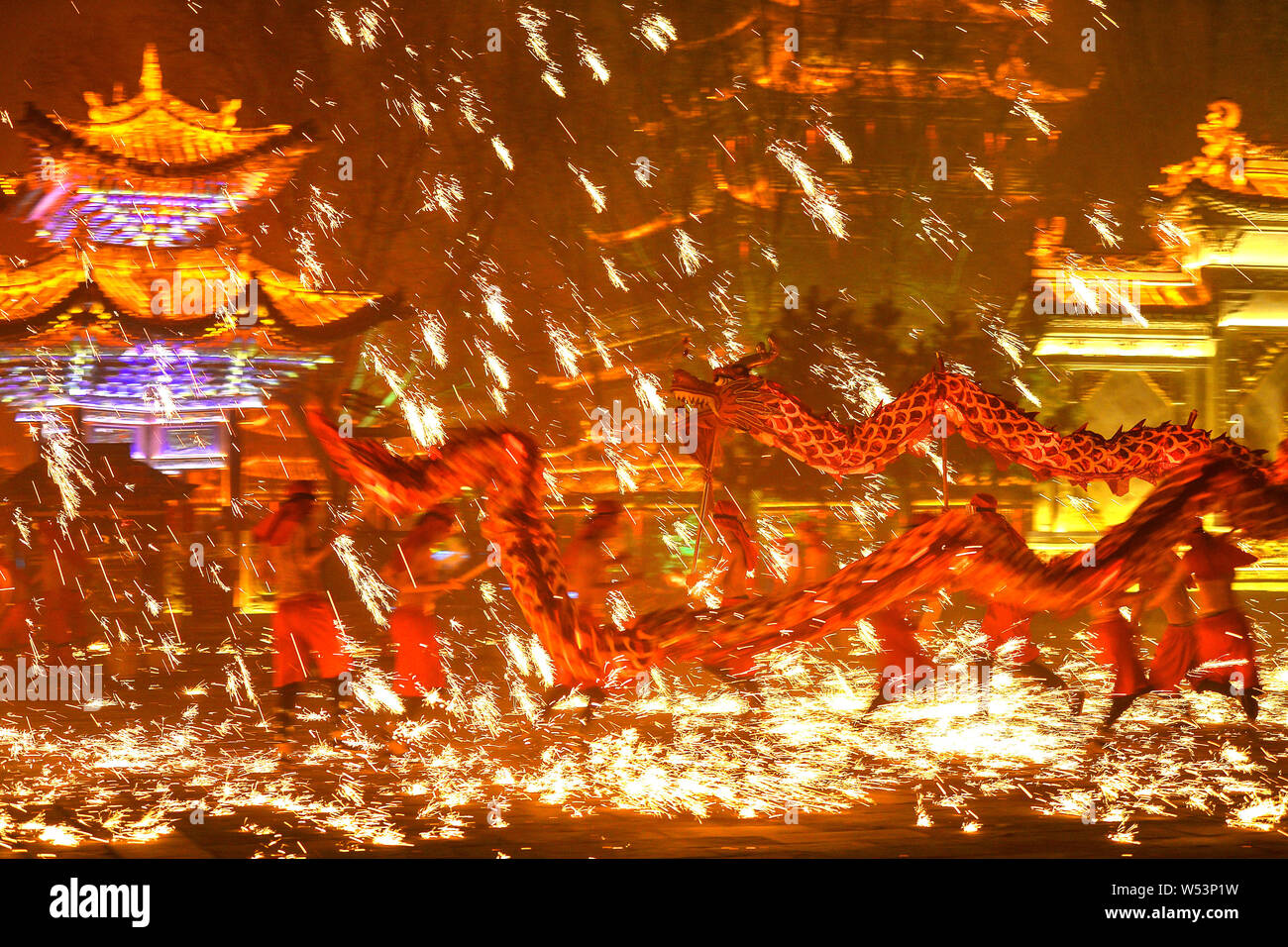Performers perform dragon dance as sparks created by molten iron water ...