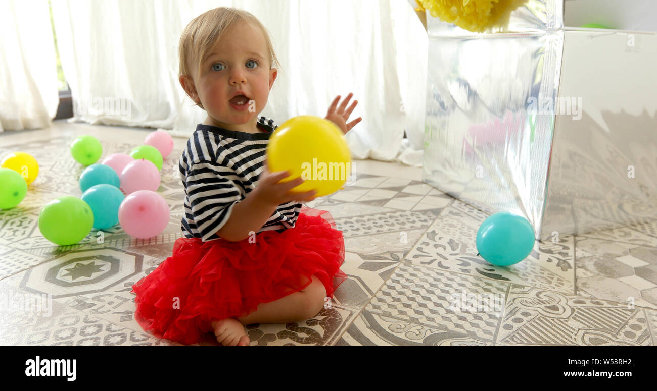 Little girl playing with colorful little balloons Stock Photo - Alamy