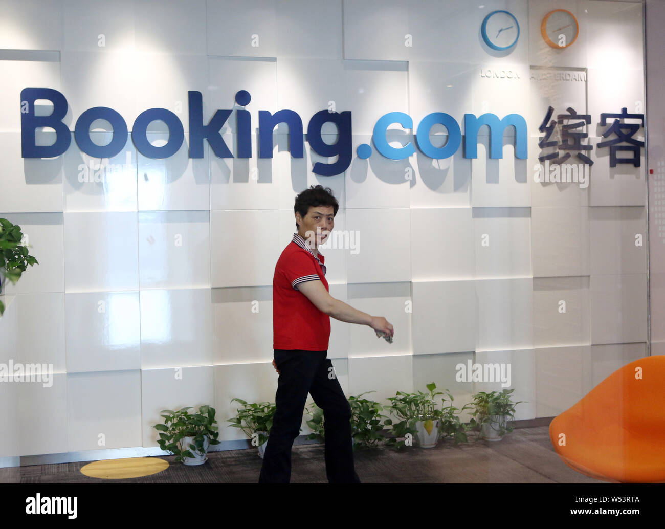 --FILE--A Chinese employee poses in the office of online hotel ...