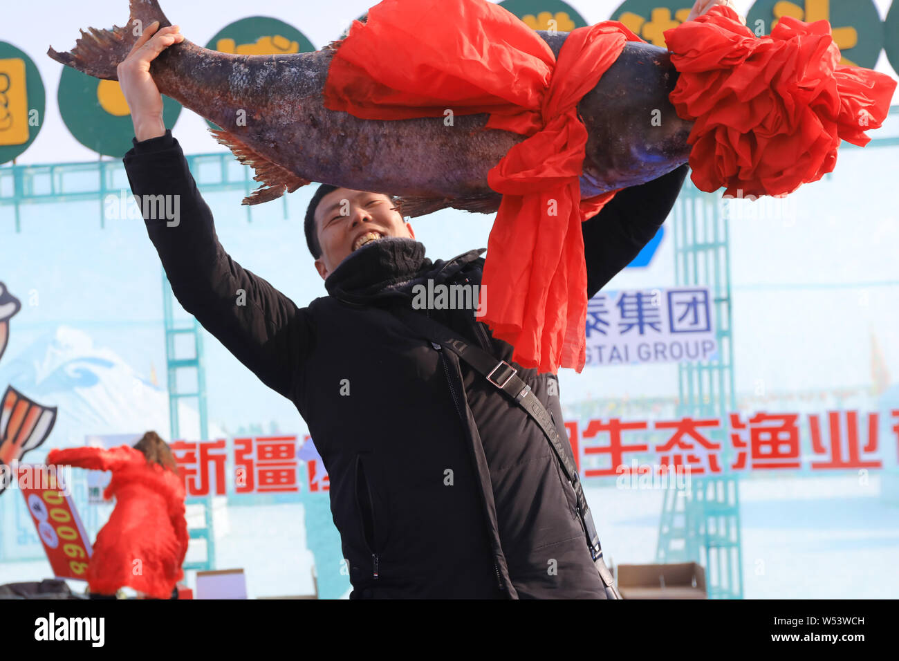 The owner holds up a 23-kilogram fish, which is the biggest catch ...