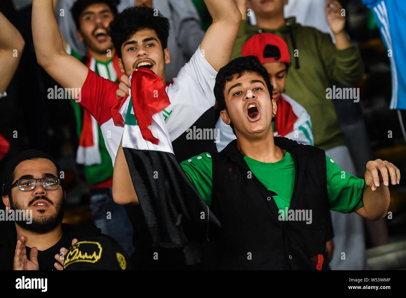 Iraqi football fans hold up their national flags to show support for ...