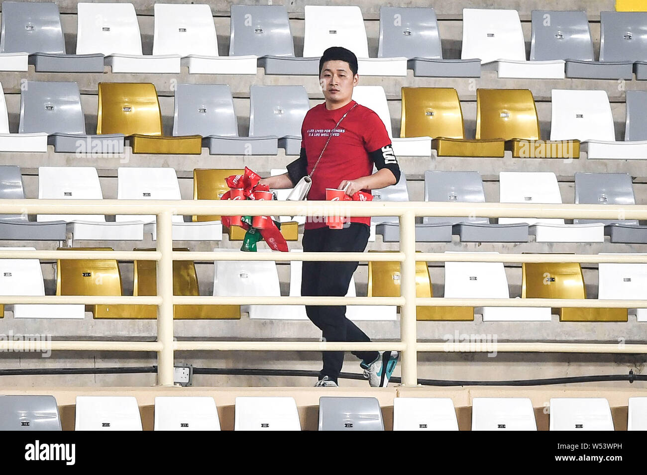 A Chinese football fan cleans the stadium's stand after China was ...